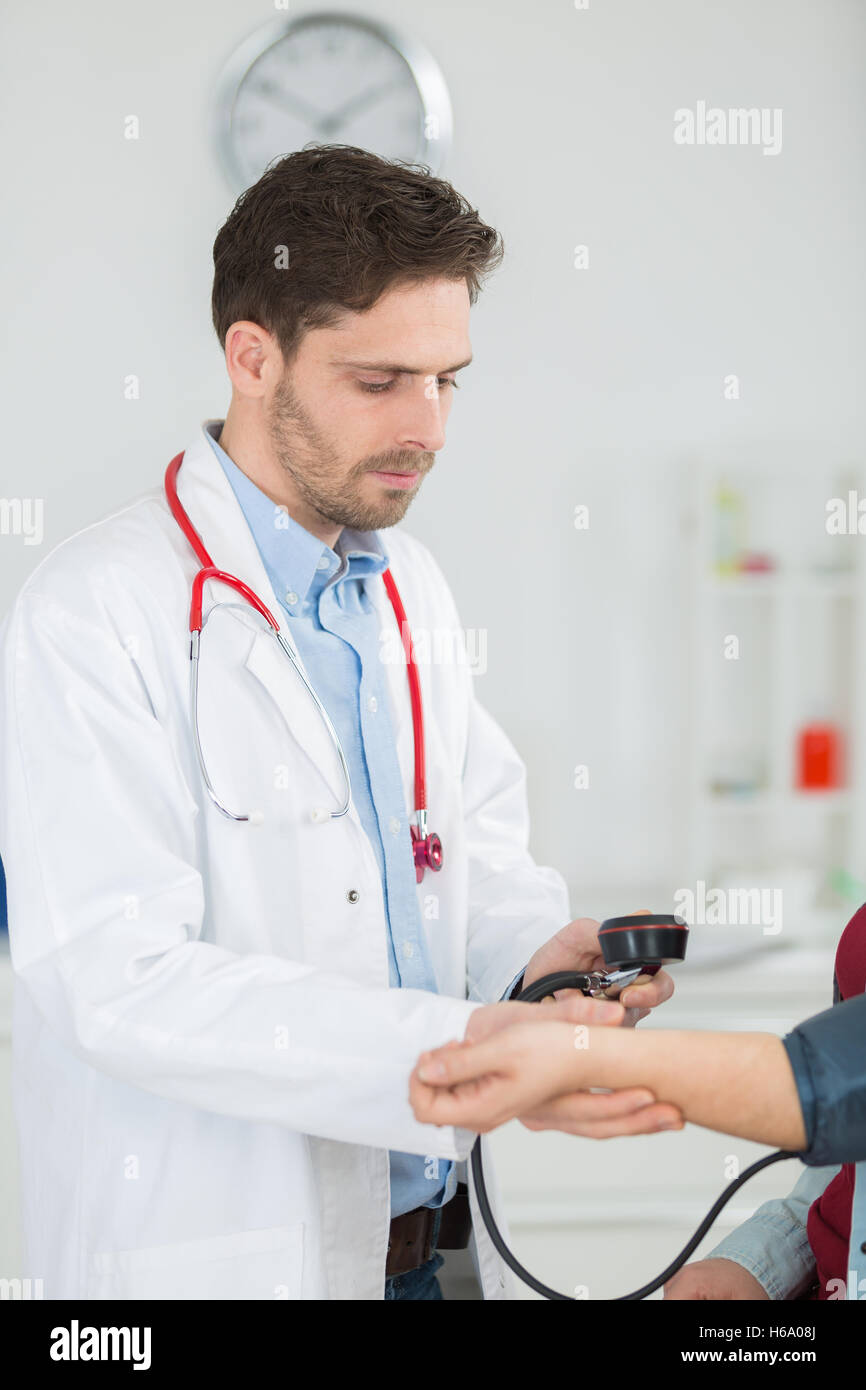 portrait of happy doctor checking patients blood pressure in clinic ...