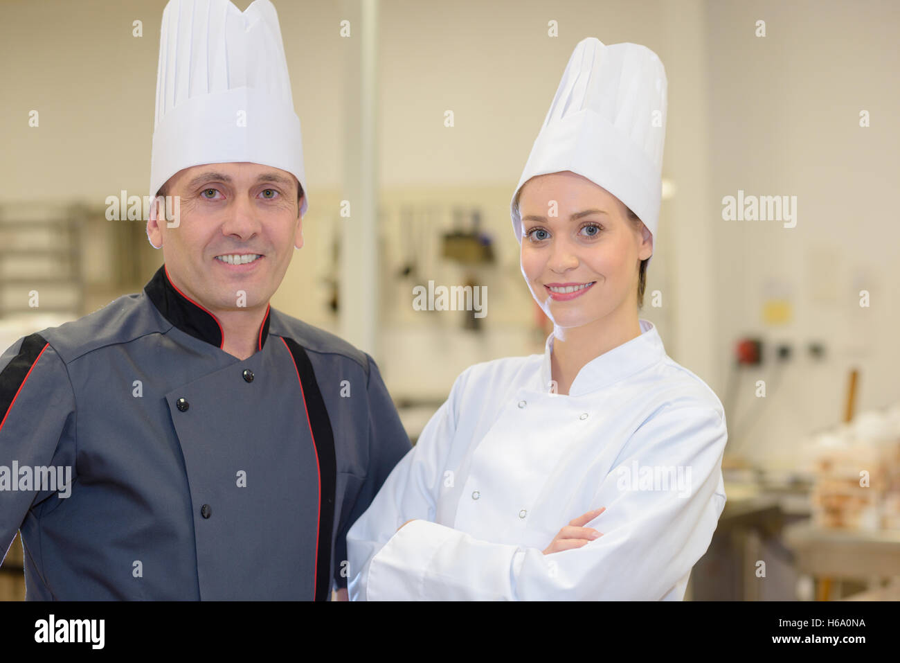 a male and female chef posing in restaurant kitchen Stock Photo - Alamy