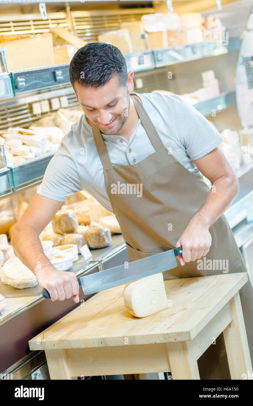 Local deli worker slicing some cheese Stock Photo - Alamy