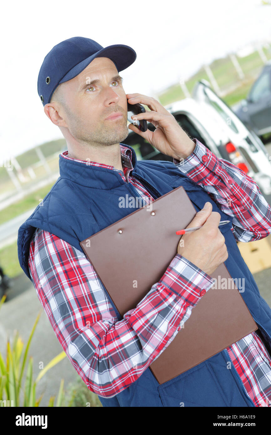 worker wearing cap using mobile phone in the warehouse Stock Photo - Alamy