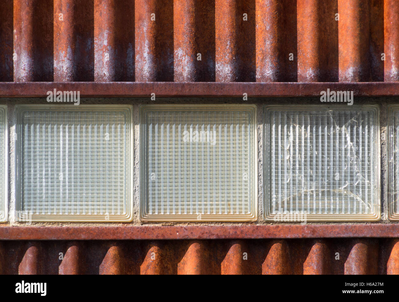Close Up of Rusty Corrugated Metal Wall with Three Glass Blocks, One of ...