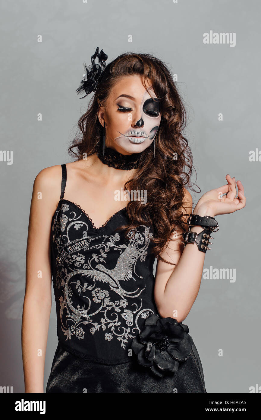 Young woman in black with half face skull make-up Stock Photo - Alamy