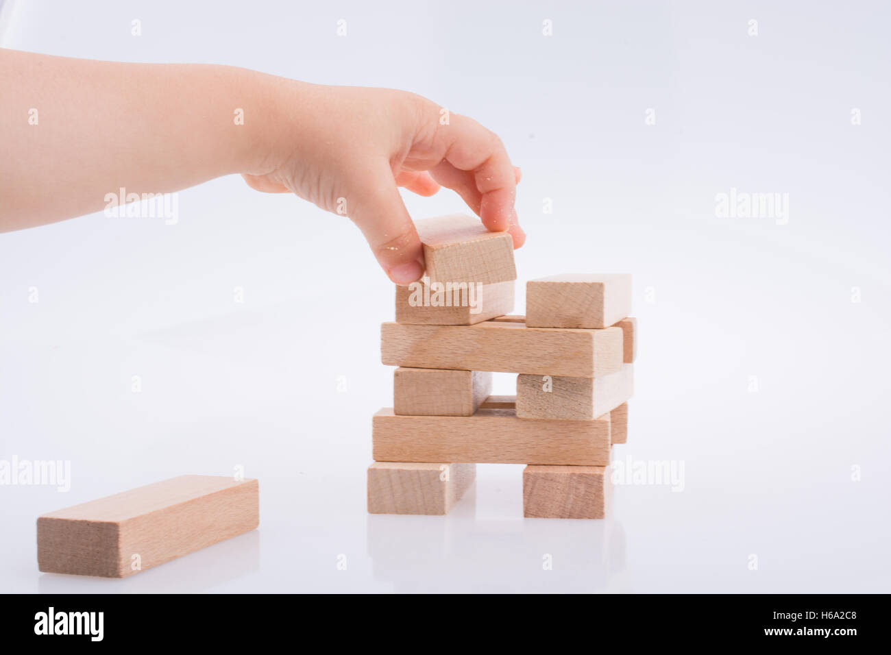 Hand playing with wooden building blocks on white background Stock ...