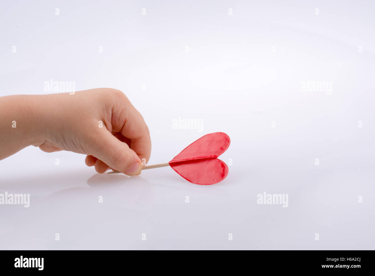Little red color heart shape at the top of a stick in hand Stock Photo ...
