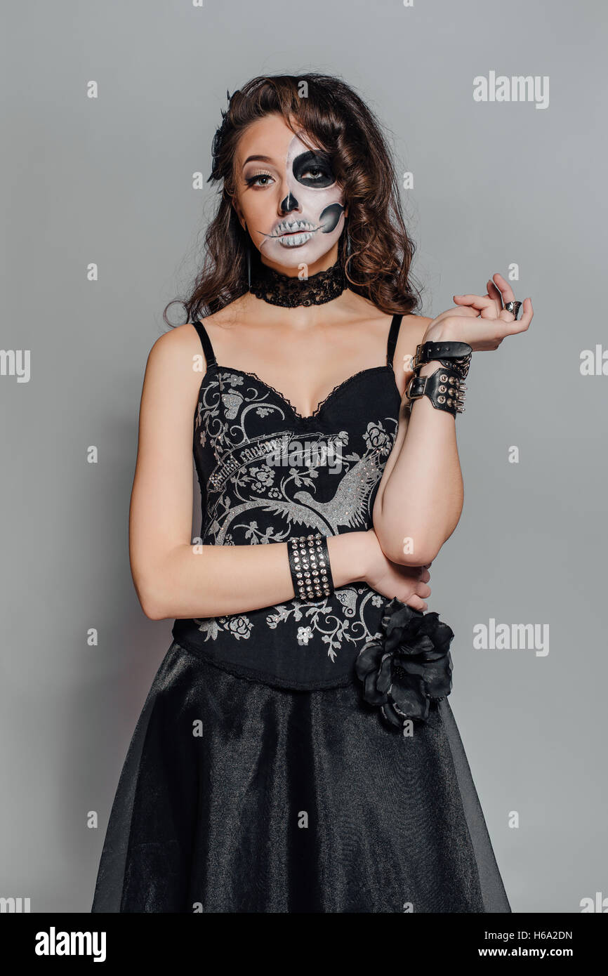 Young woman in black with half face skull make-up Stock Photo - Alamy