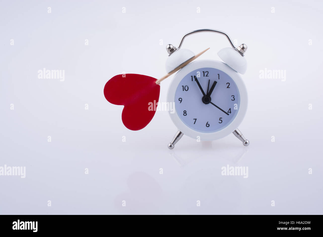 Little red color heart shape and white color alarm clock Stock Photo ...