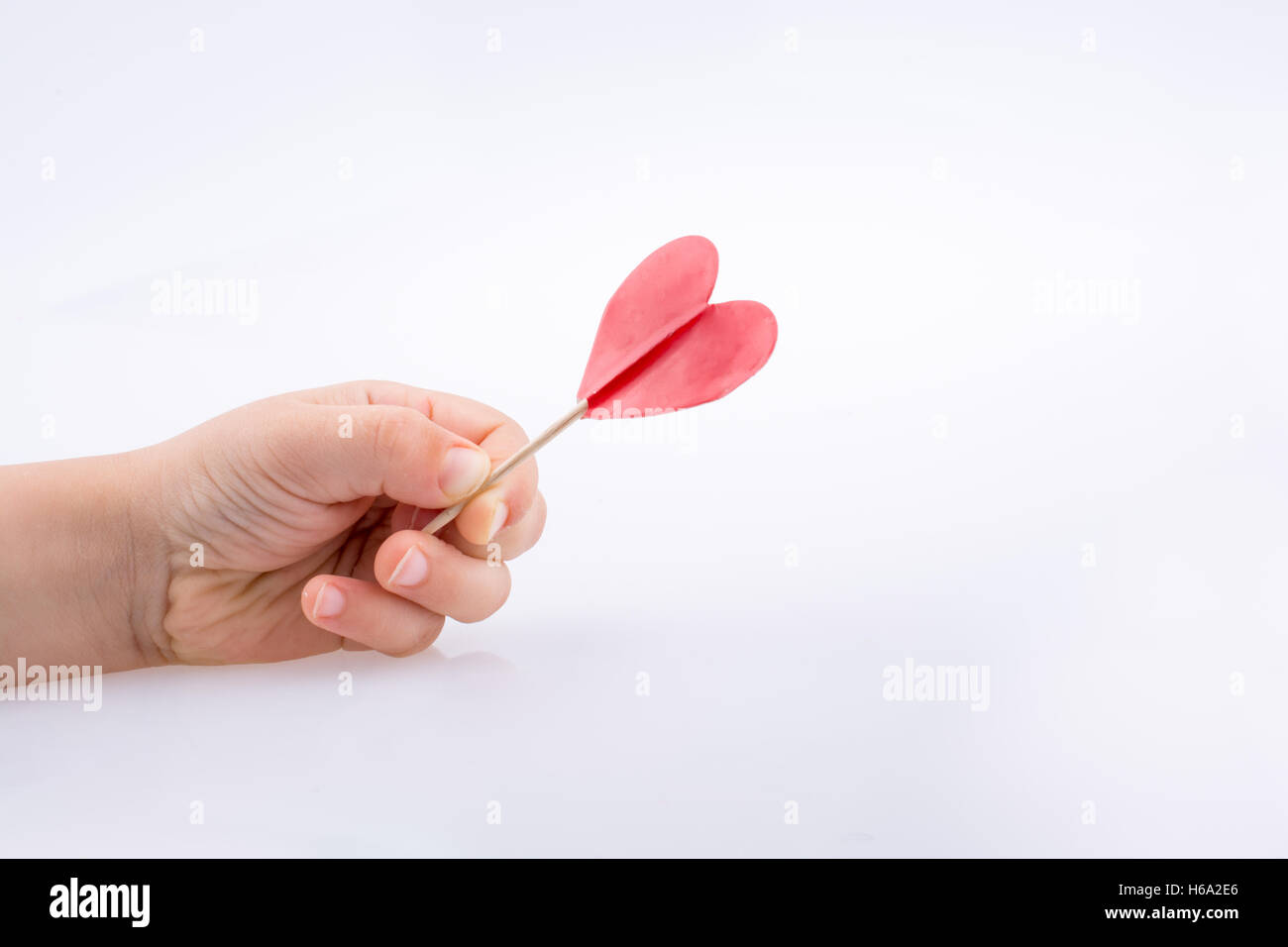 Little red color heart shape at the top of a stick in hand Stock Photo ...