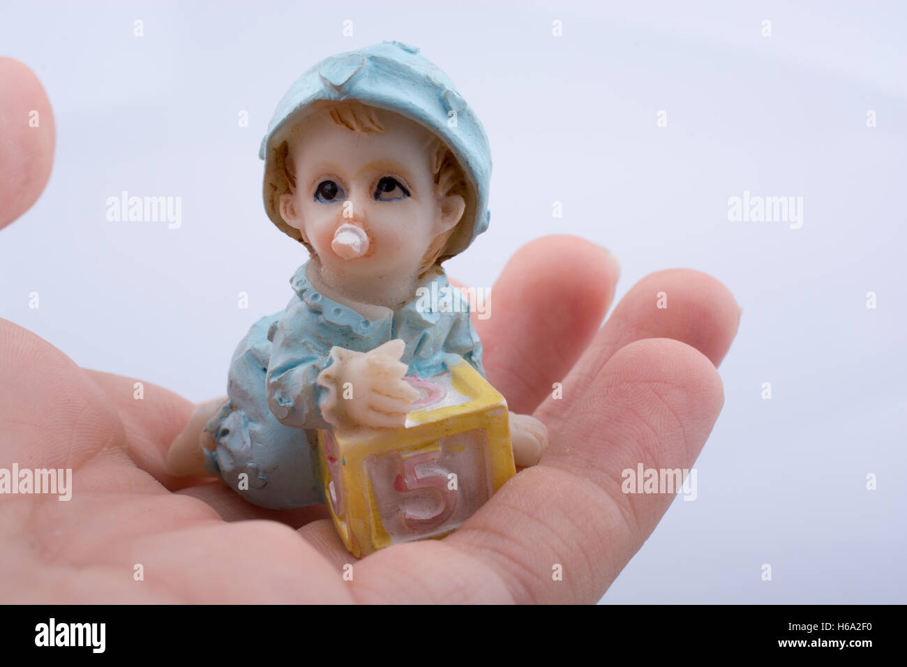 Little baby figure in hand on a white background Stock Photo - Alamy