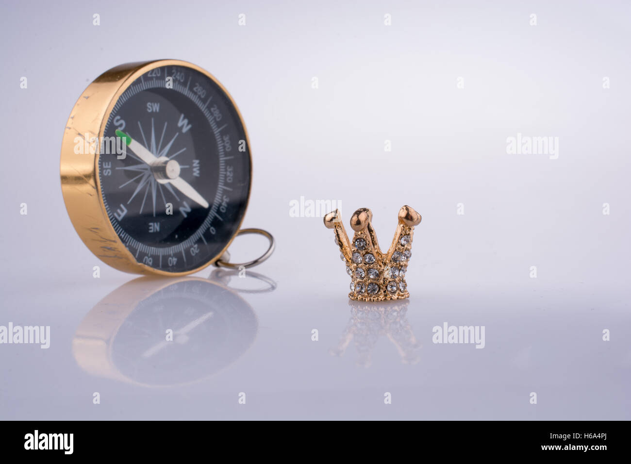Compass and Golden color crown model with pearls on white background ...