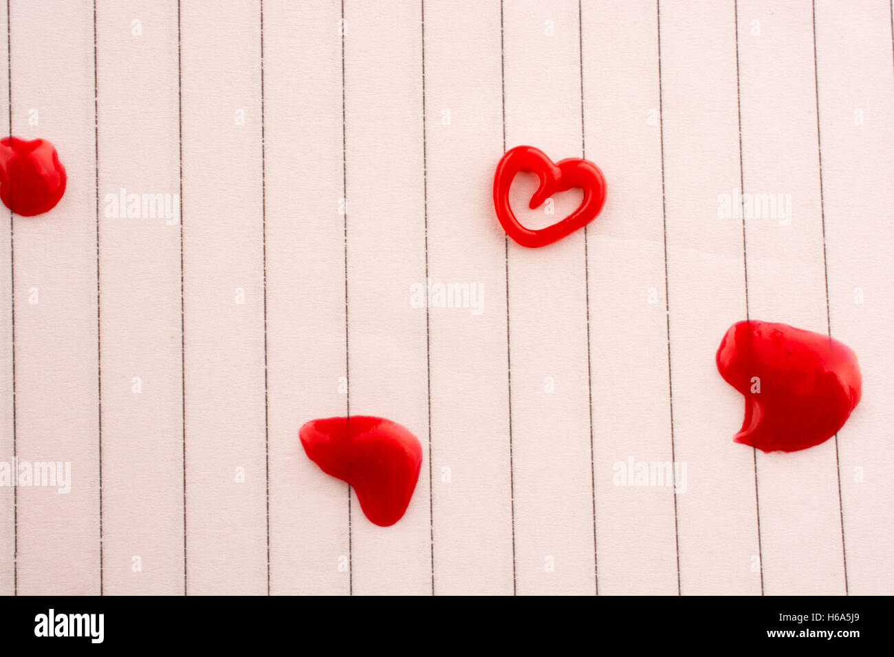 Heart shaped made by the help of a colored glue on white background ...