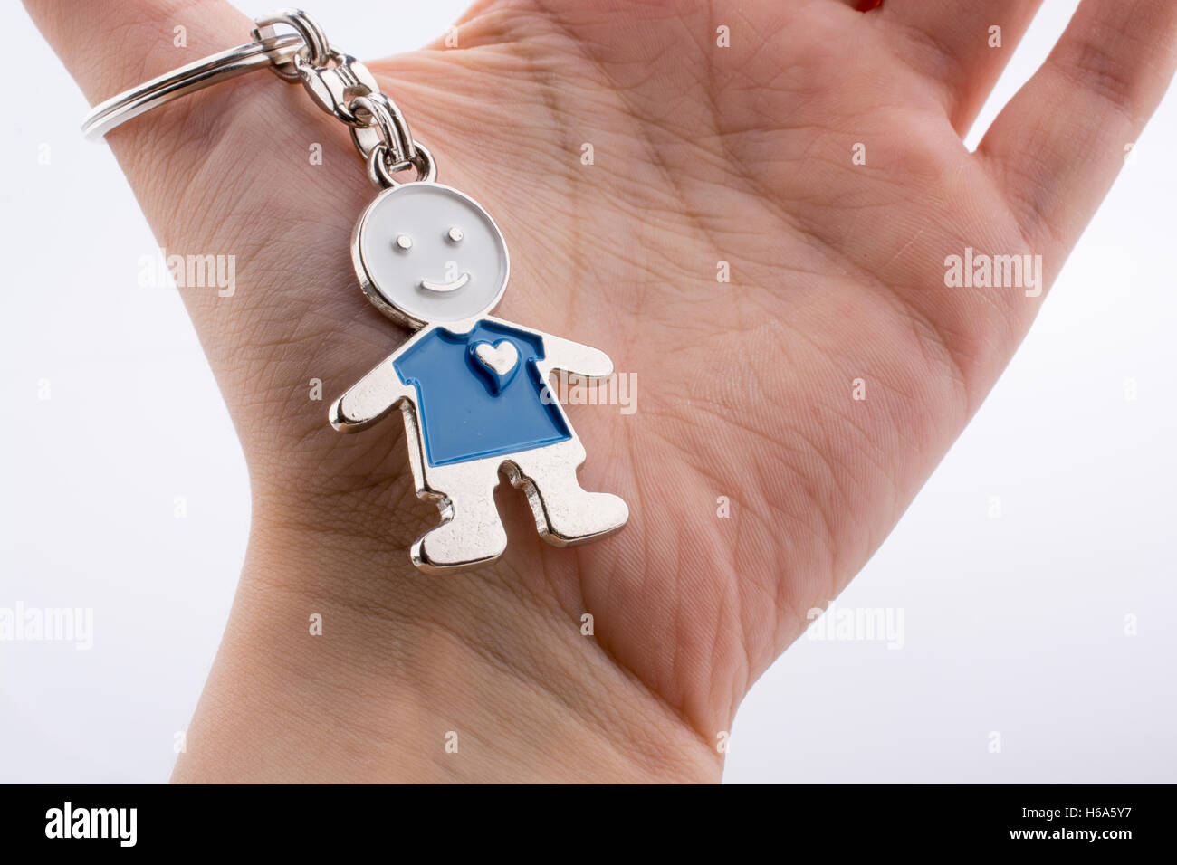 Man shaped keyholder in hand on white background Stock Photo - Alamy