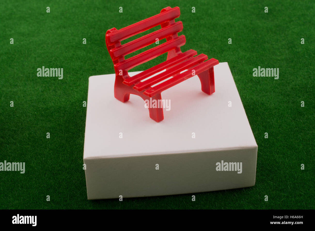 Little red miniature bench made of plastic Stock Photo - Alamy