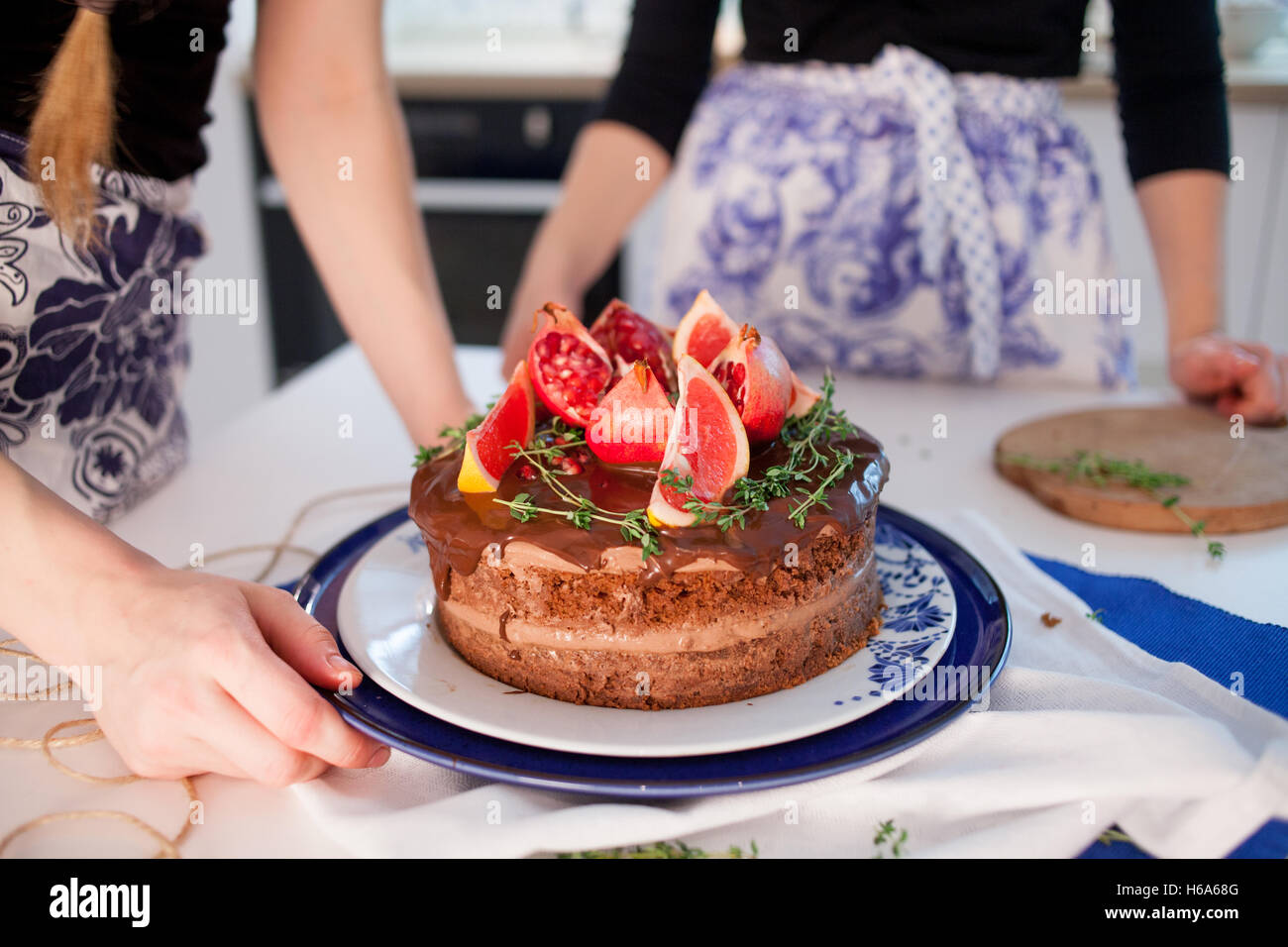 Two girls making a cake on the kitchen. Beautiful cake with cream and ...