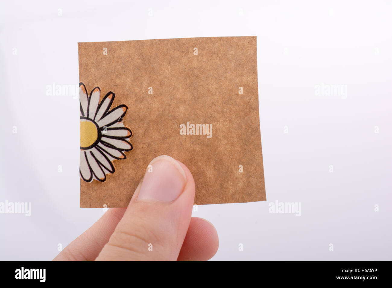 Hand holding a note paper with a floral pattern on a white background ...
