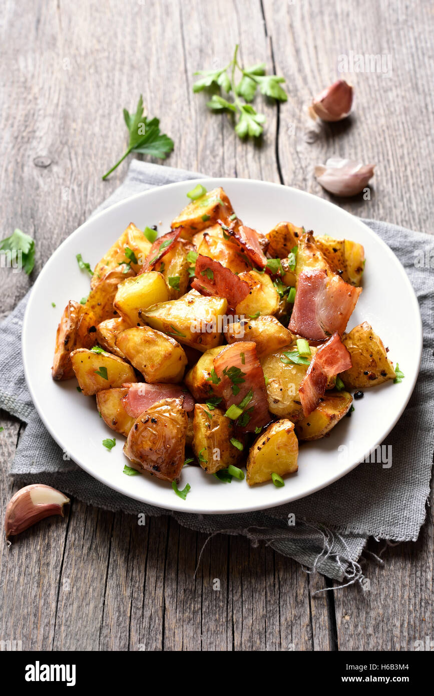 Roasted potato on plate over wooden background Stock Photo - Alamy