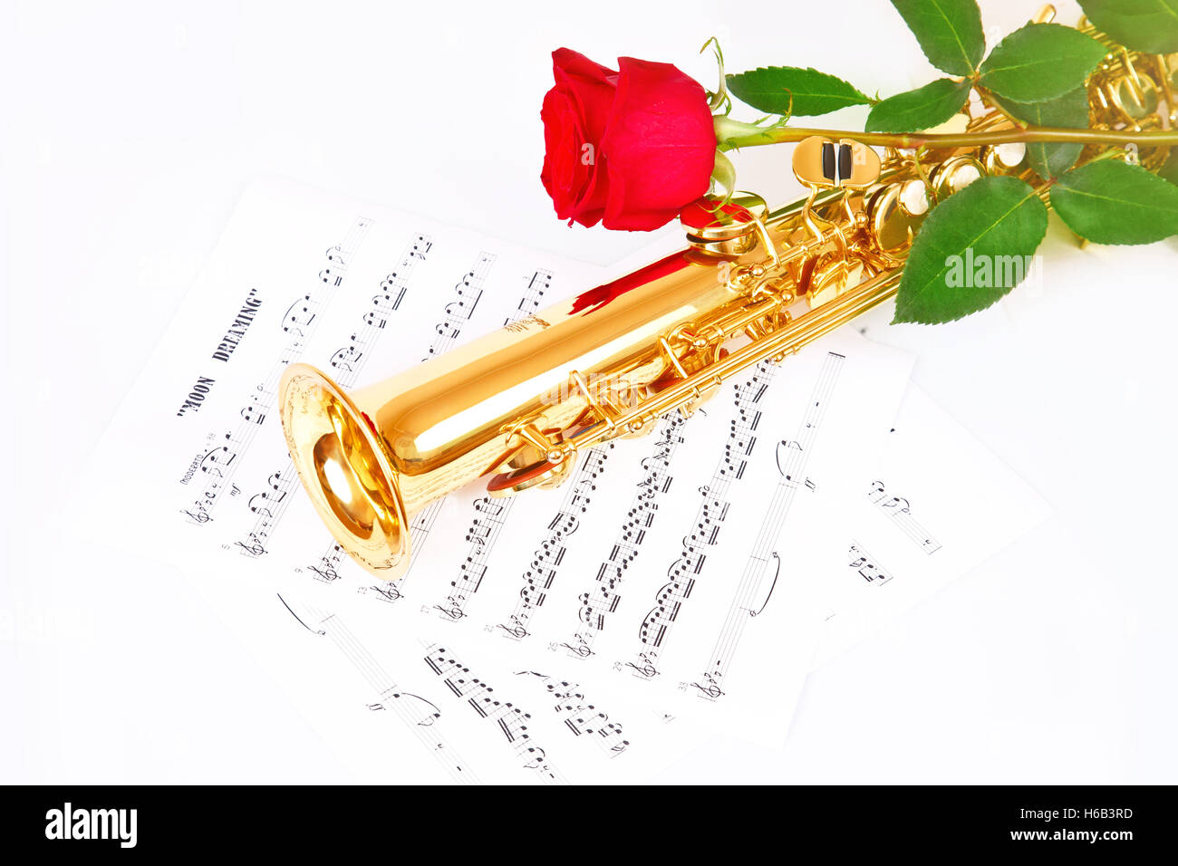 Red rose, saxophone and music sheet on a white background Stock Photo ...