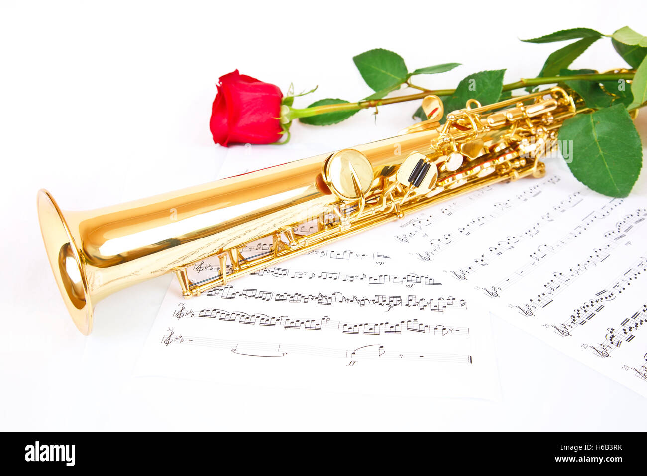 Red rose, saxophone and music sheet on a white background Stock Photo ...