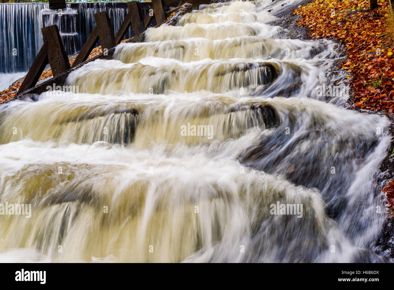 Fish ladder with rapids in fall. Water flowing in steps is helpful for ...