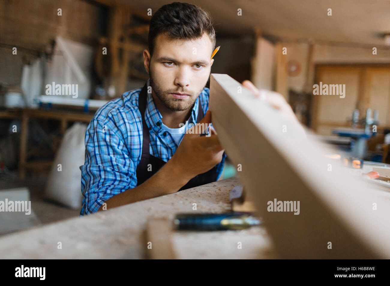 Checking straightness of plank Stock Photo - Alamy