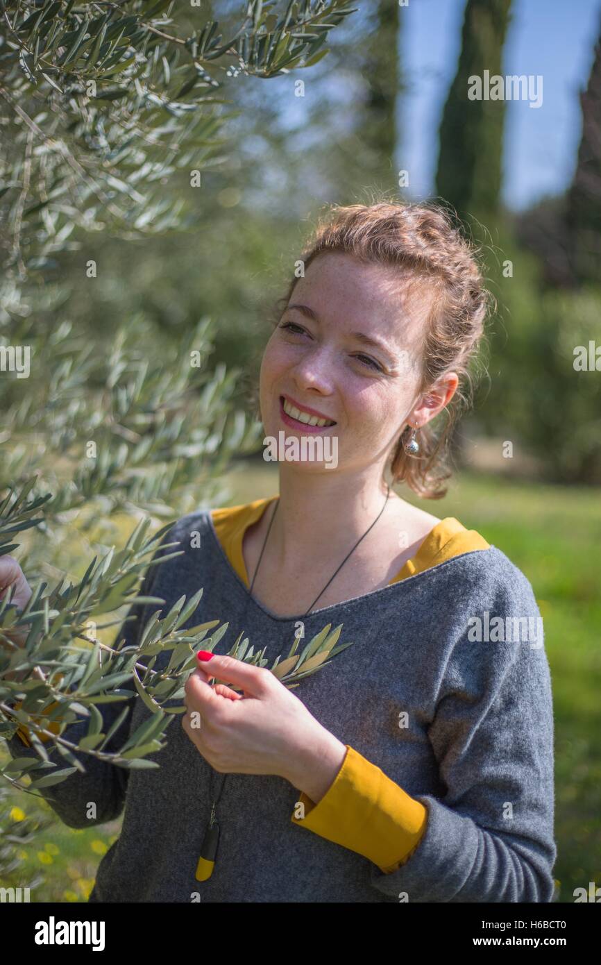 Young woman with an olive tree in a garden Stock Photo - Alamy