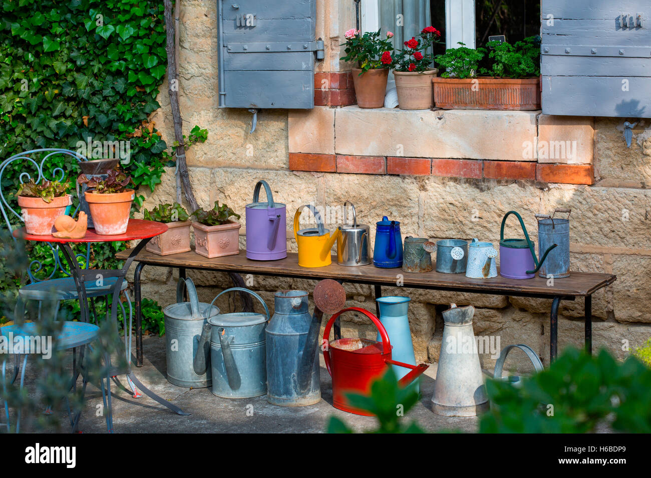 Collection of watering cans on a bench, Provence, France Stock Photo ...