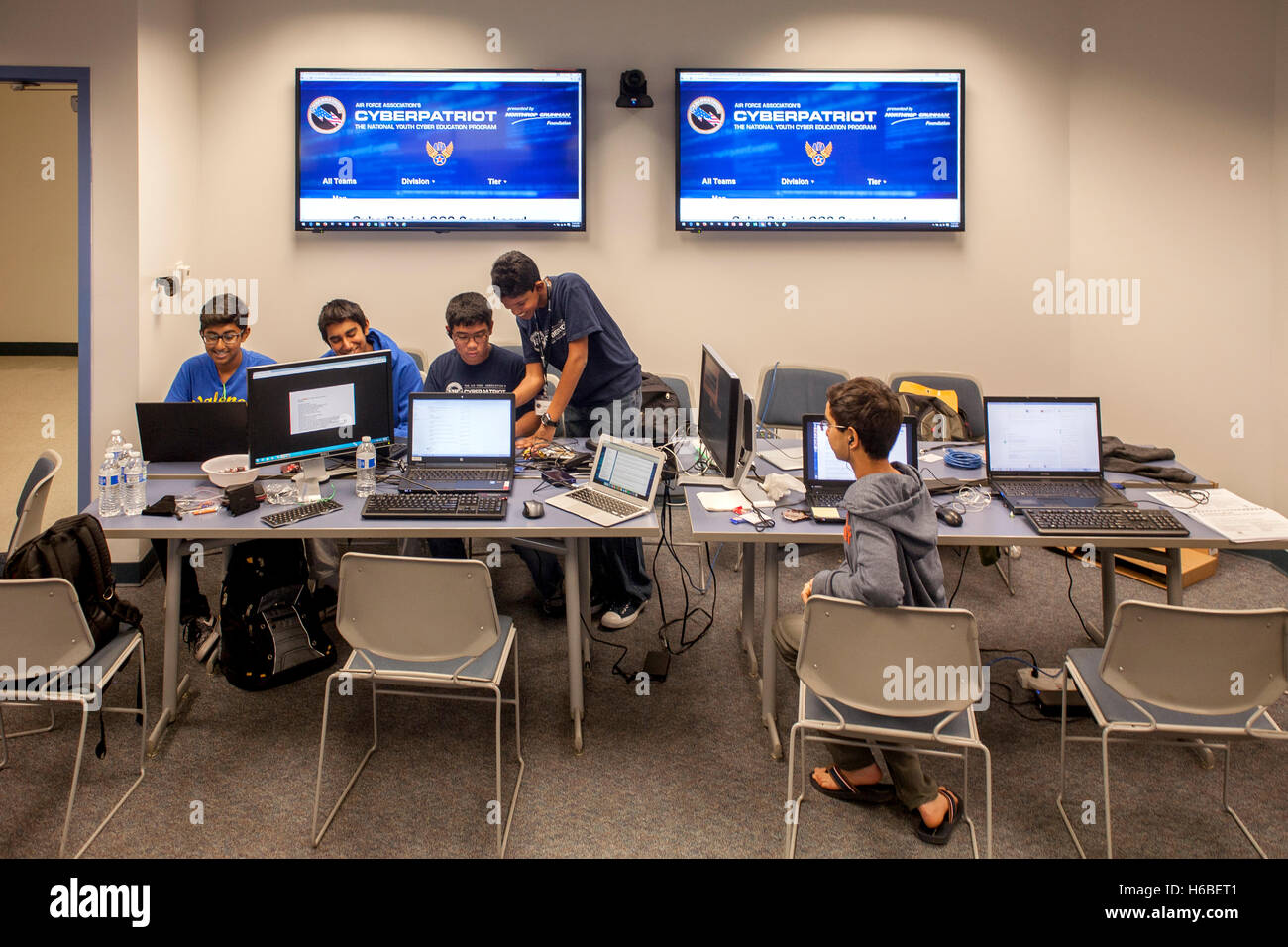 Enthusiastic multiracial teen boys compete in the CyberPatriot Cyber ...