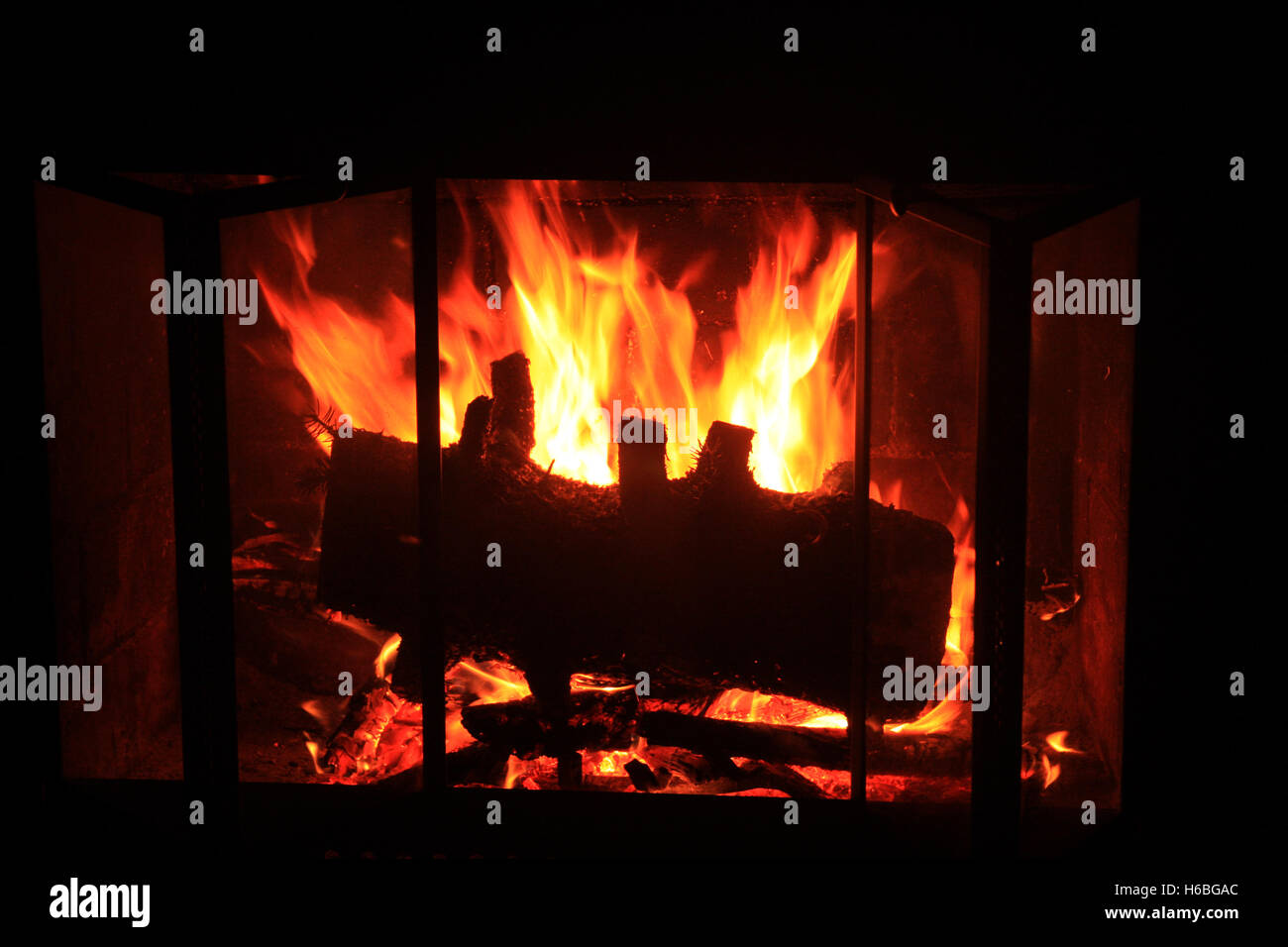 Large log burning in fireplace Stock Photo - Alamy