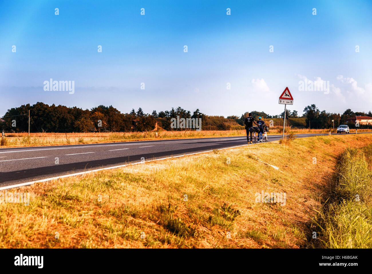 cyclists walking on a highway with the bicycle at their side Stock ...