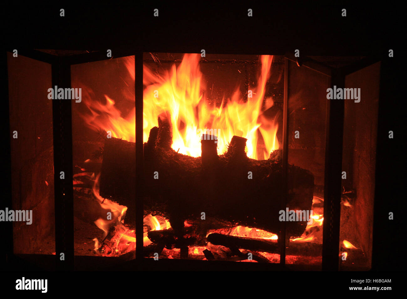 Large log burning in fireplace Stock Photo - Alamy