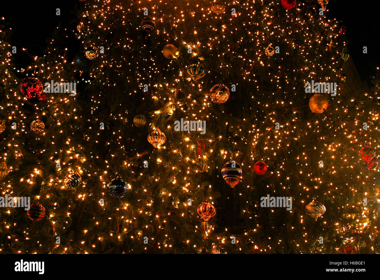 Globes and lights in large Christmas tree Stock Photo - Alamy