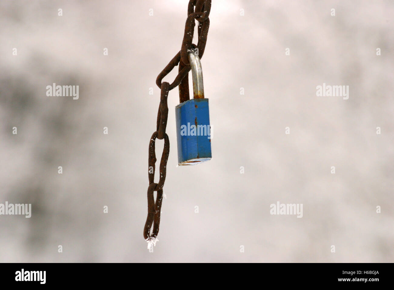 Blue old lock on rusty chain on neutral background Stock Photo - Alamy