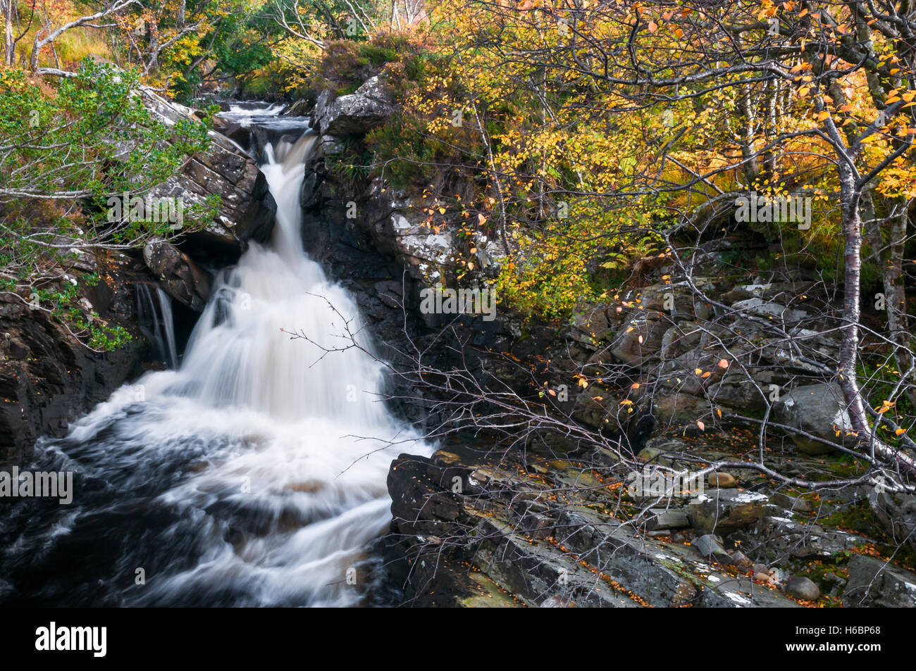 A small secluded waterfall surrounded by rock and trees Stock Photo - Alamy