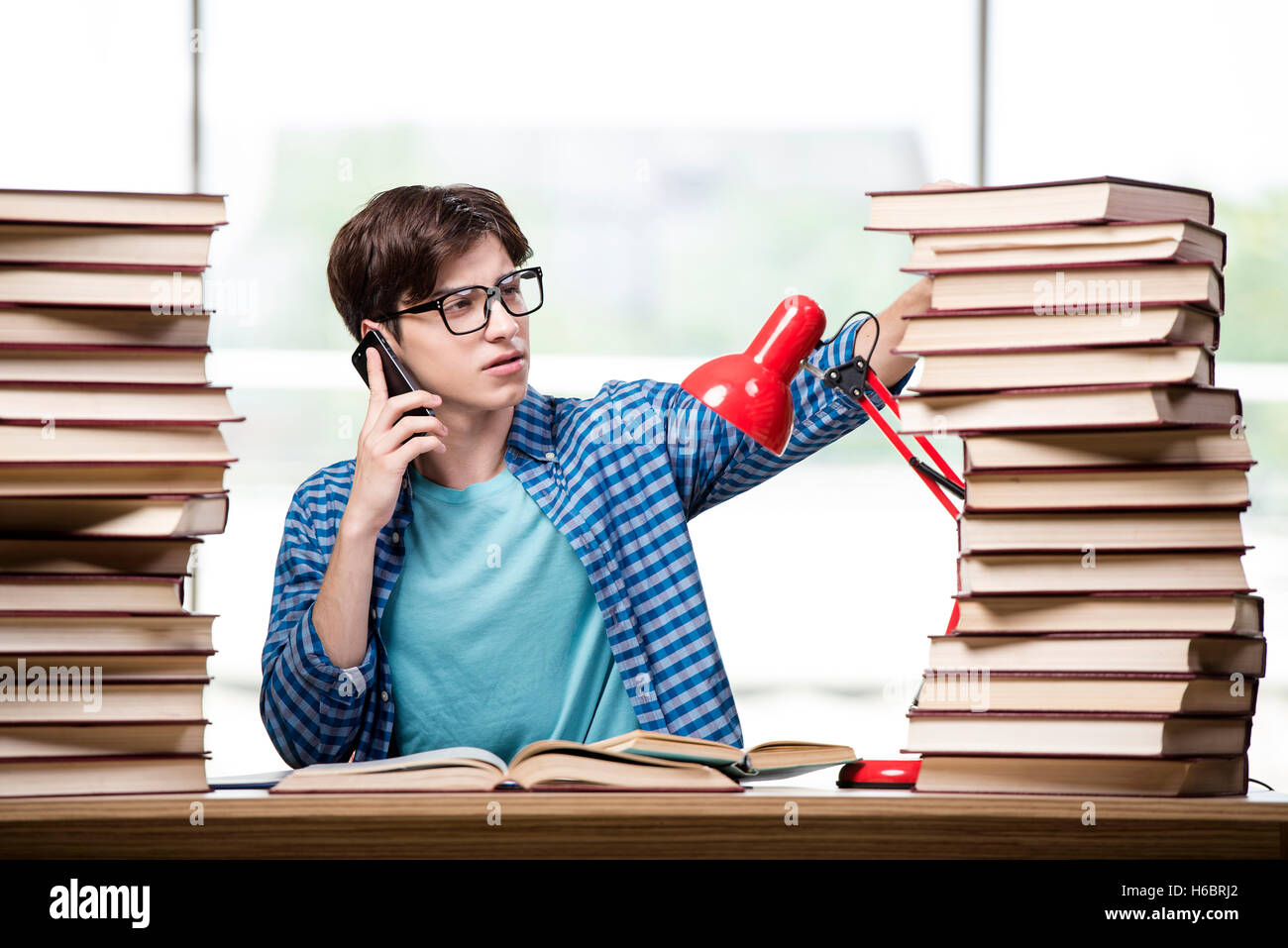 Student with lots of books preparing for exams Stock Photo - Alamy