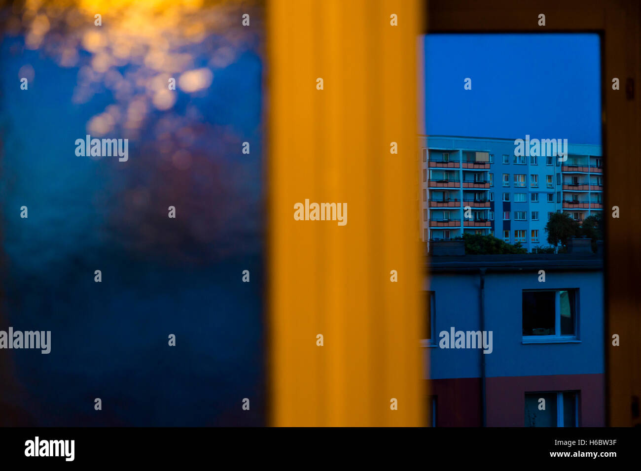 Tungsten lighting reflecting off a bumpy window, with another window in ...