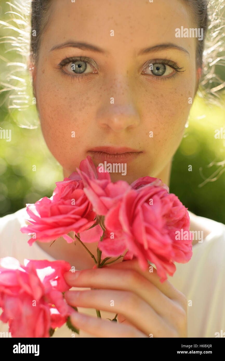 Young woman with pink roses, portrait Stock Photo - Alamy