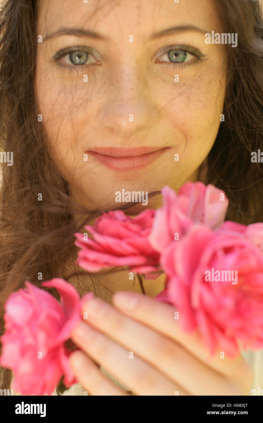 Young woman with pink roses, portrait Stock Photo - Alamy