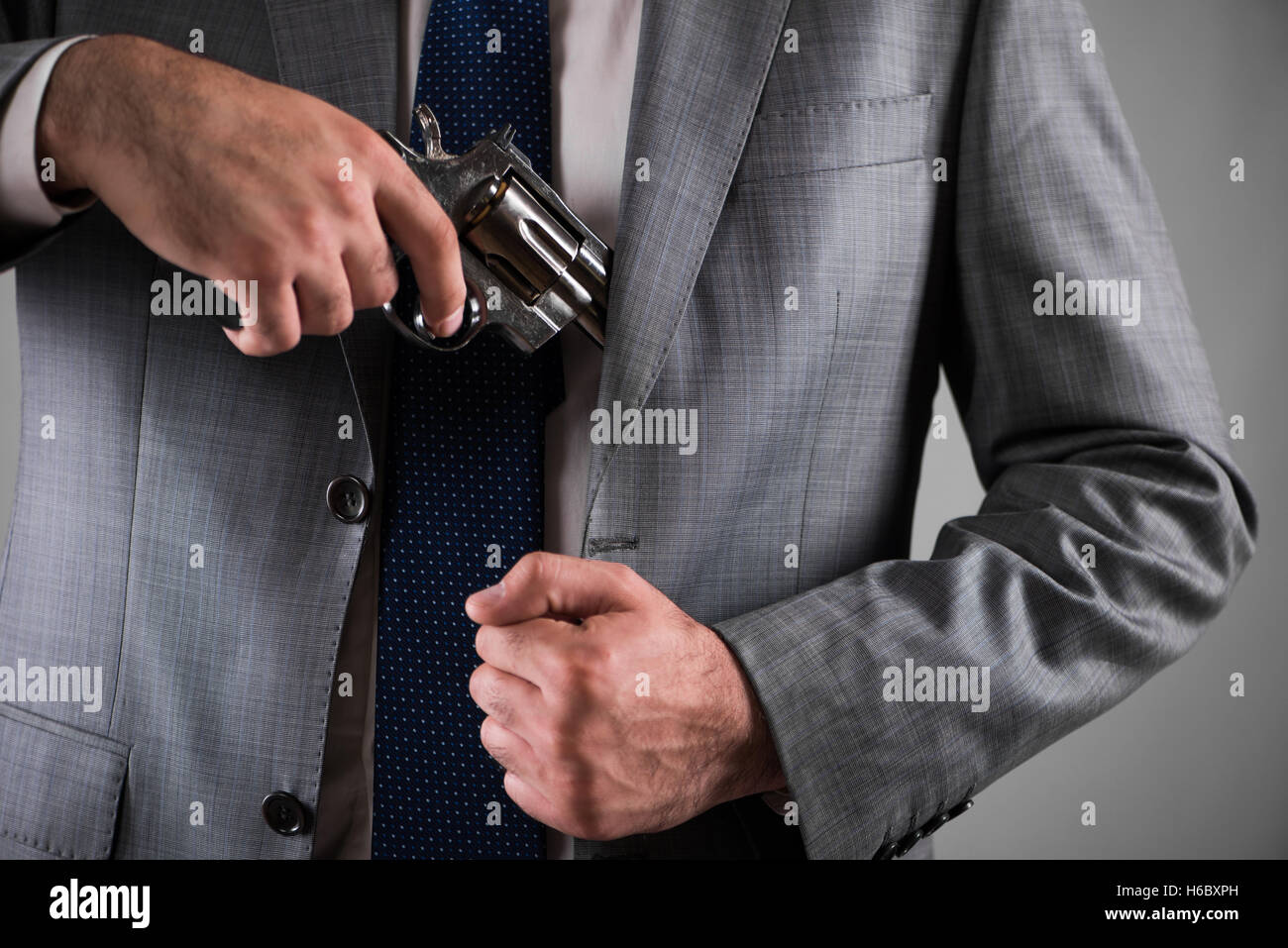 Man pulling out gun from his pocket Stock Photo - Alamy