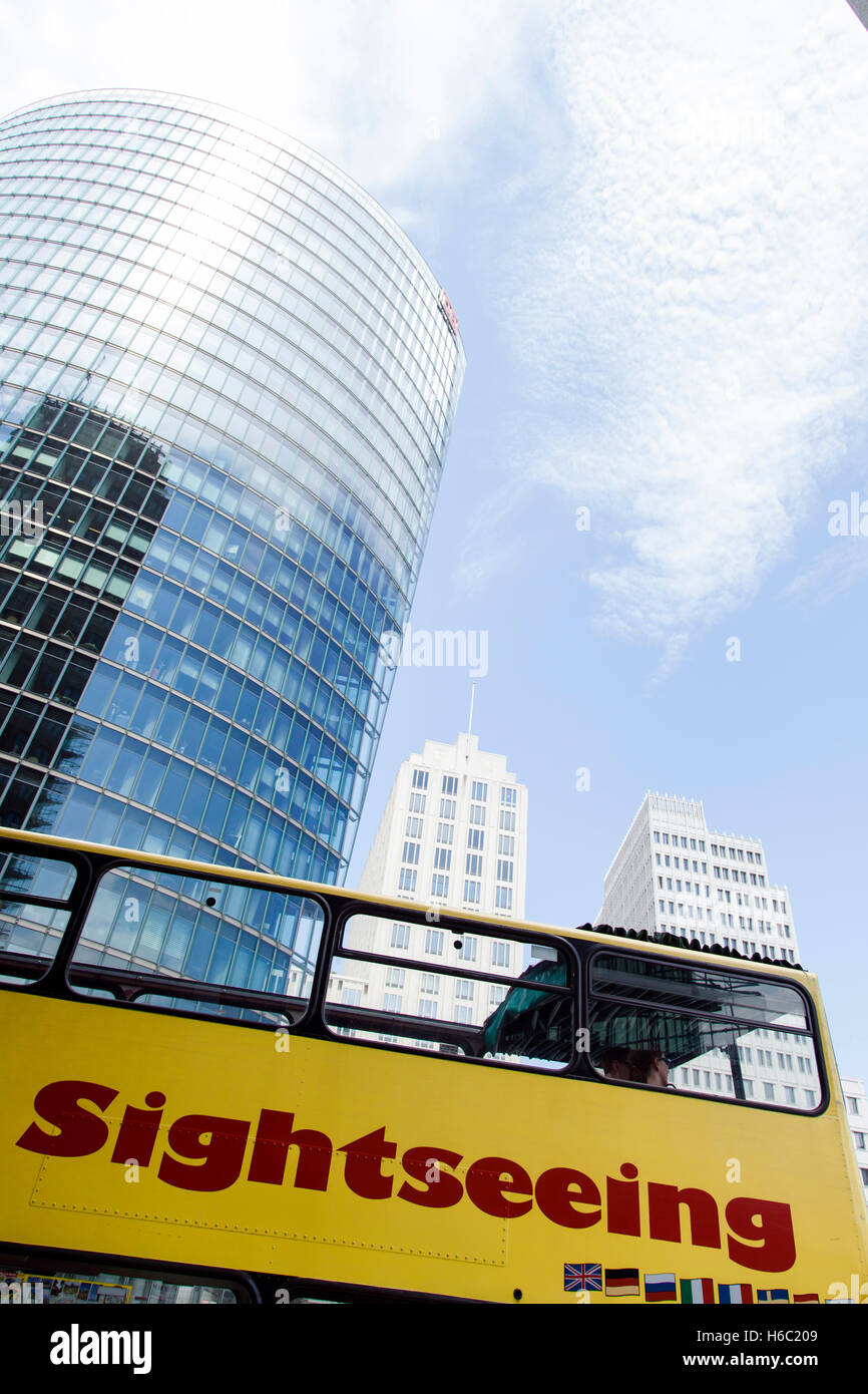 Double decker bus among tall office buildings, with "sightseeing" sign ...