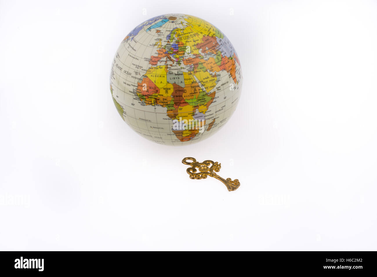 Retro styled key by the globe on white background Stock Photo - Alamy