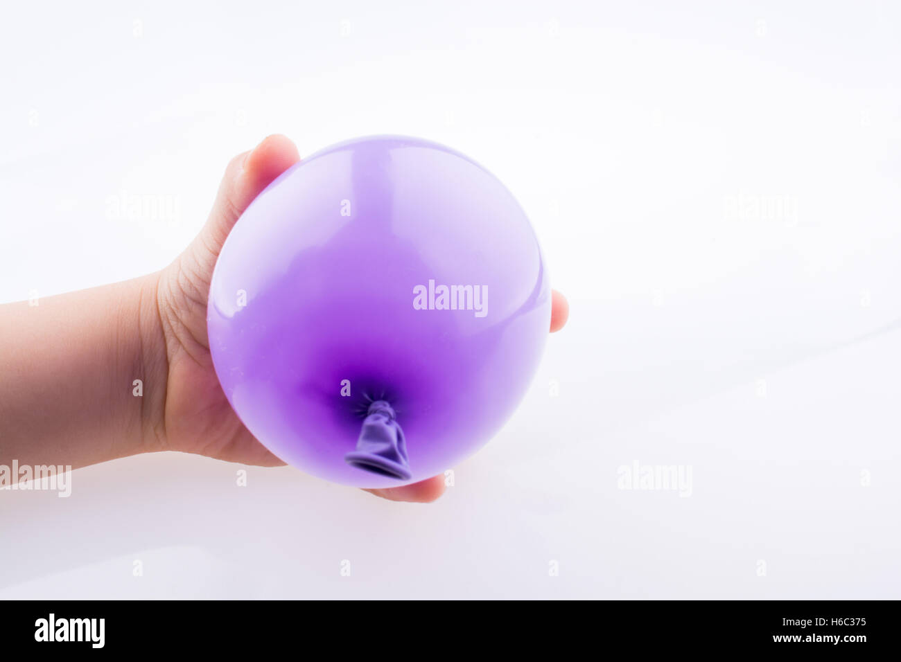 Hand holding a Colorful small balloon on a white background Stock Photo ...