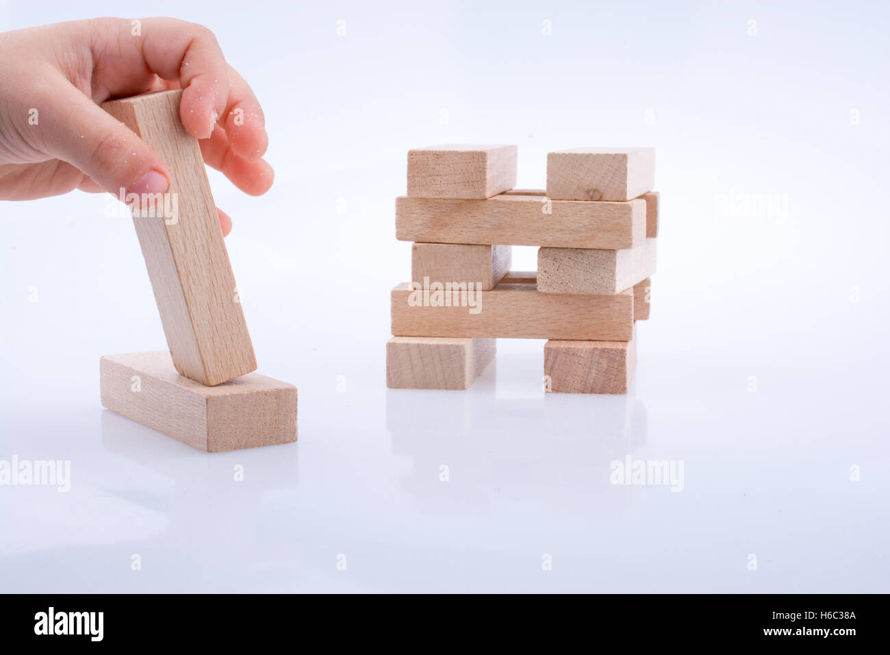 Hand playing with wooden building blocks on white background Stock ...