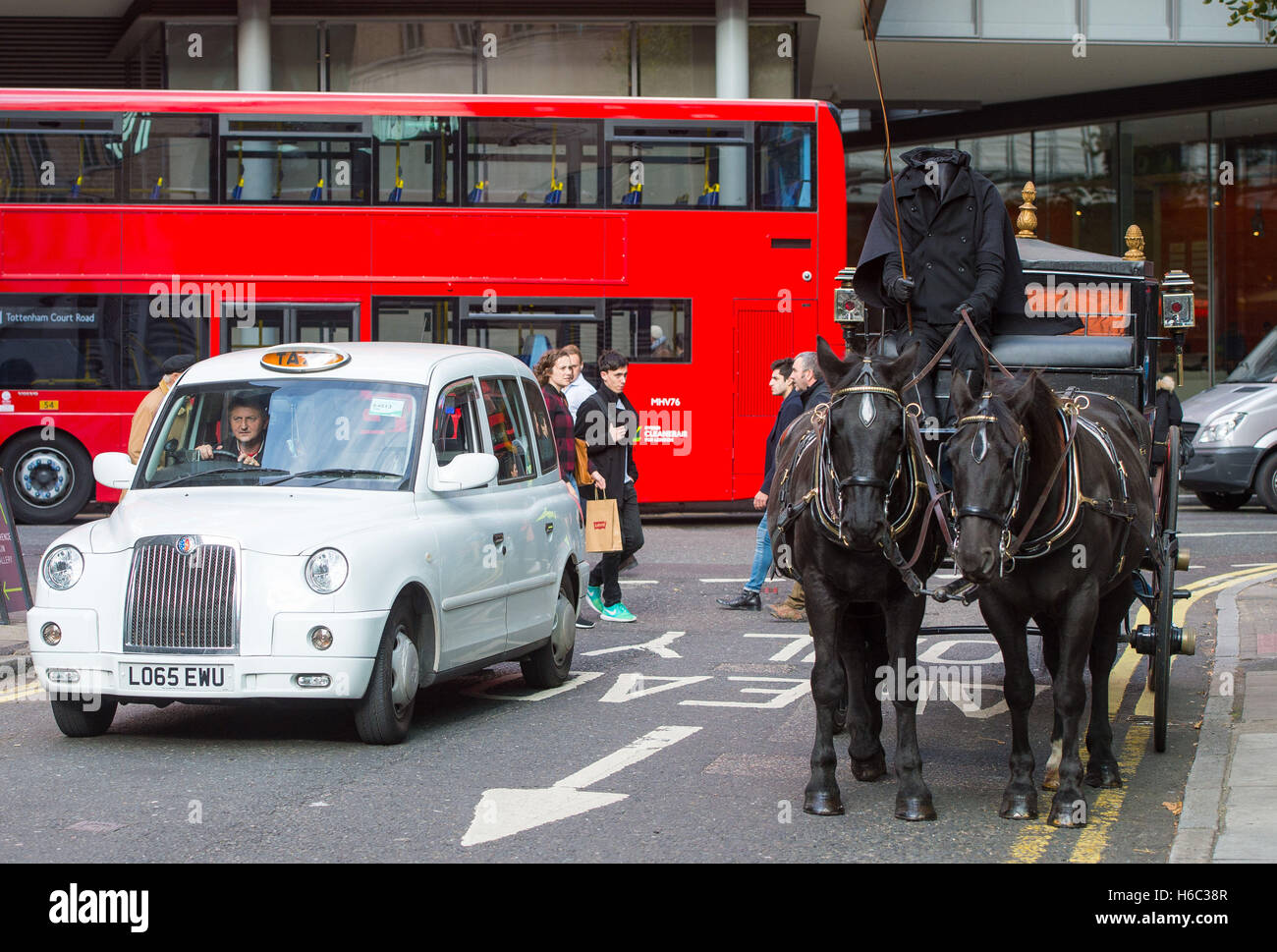 A taxi passes a 'headless horseman' riding a horse-drawn carriage ...