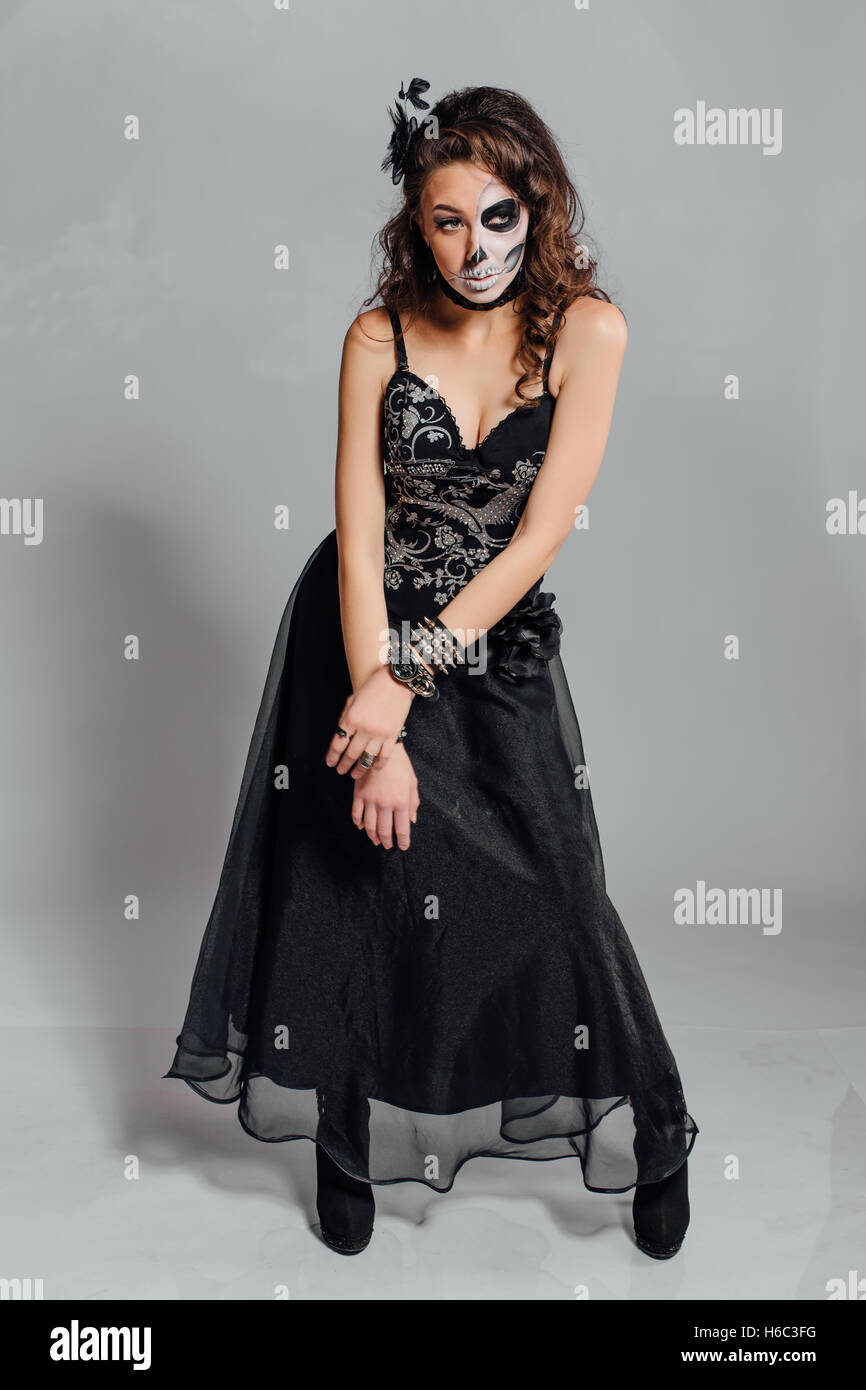 Young woman in black with half face skull make-up Stock Photo - Alamy
