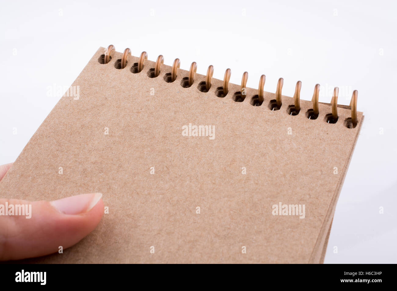 Hand holding brown color notebook on a white background Stock Photo - Alamy