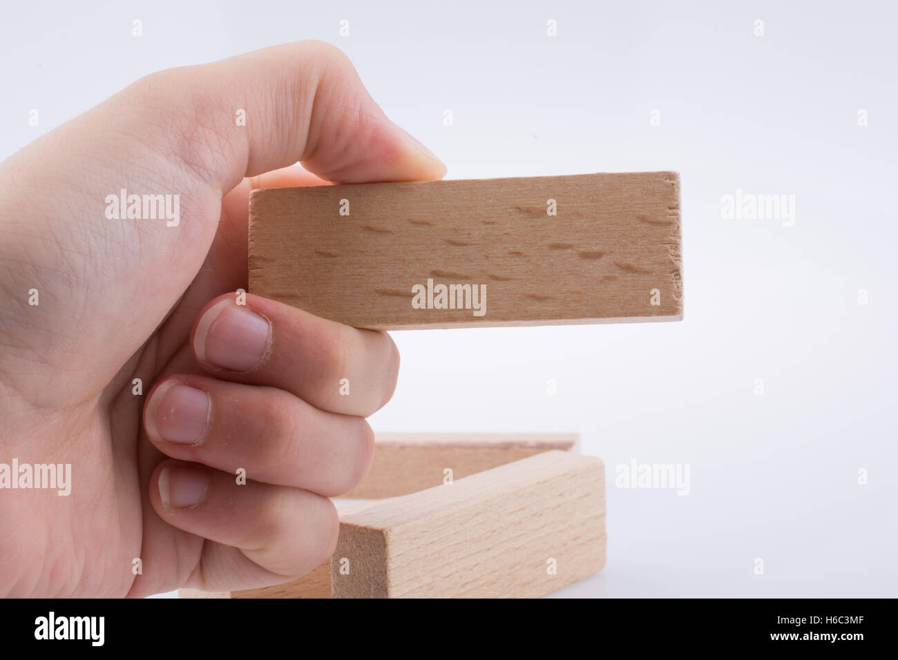 Hand playing with wooden building blocks on white background Stock ...