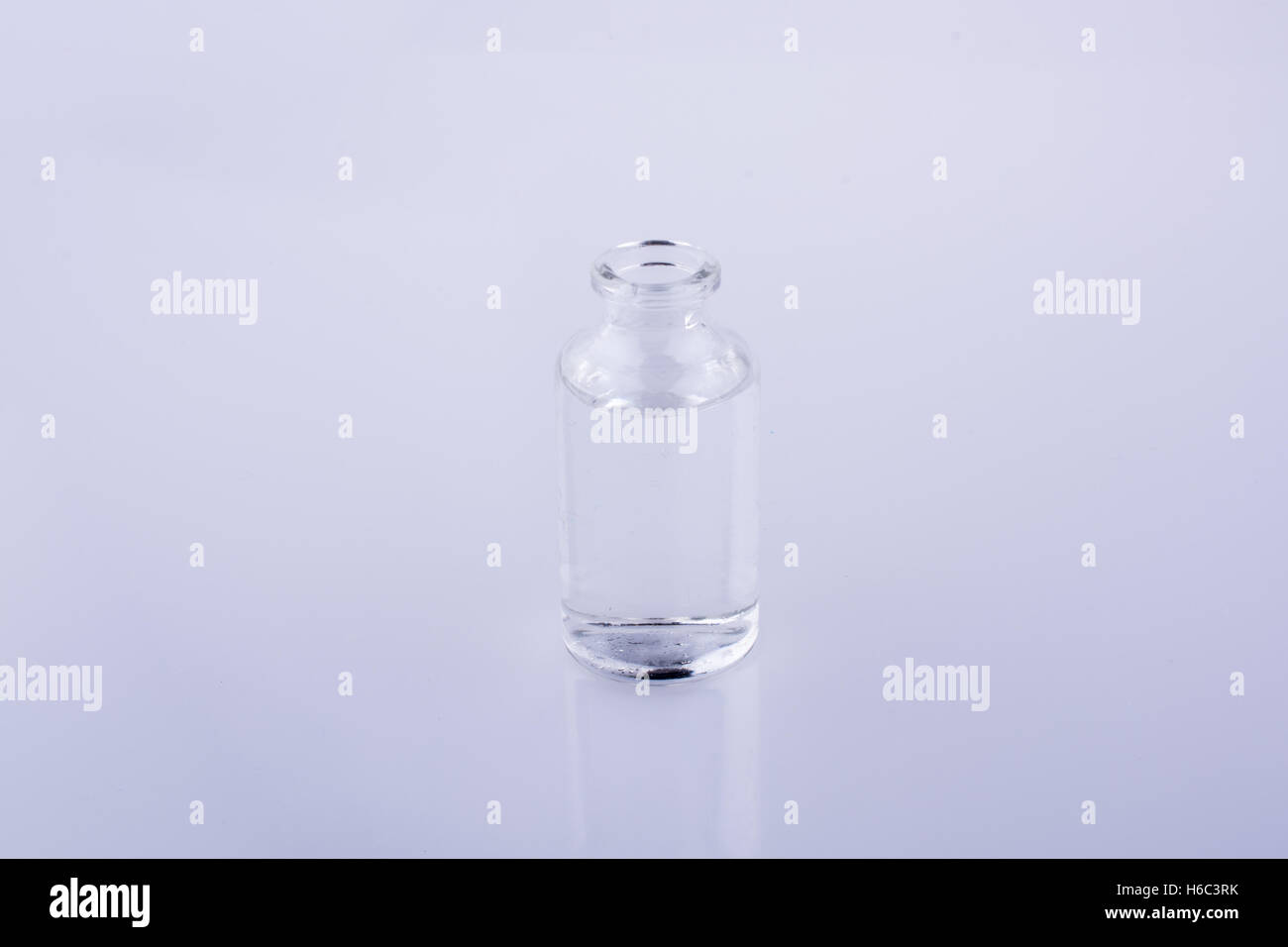 Little glass bottle in hand on a white background Stock Photo - Alamy