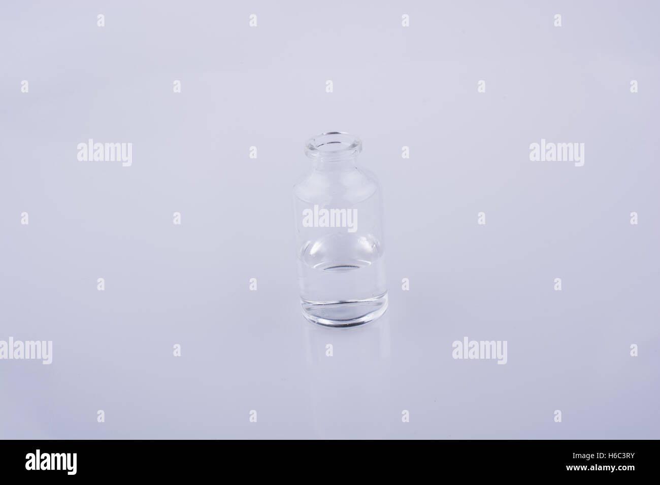 Little glass bottlewith water on a white background Stock Photo - Alamy