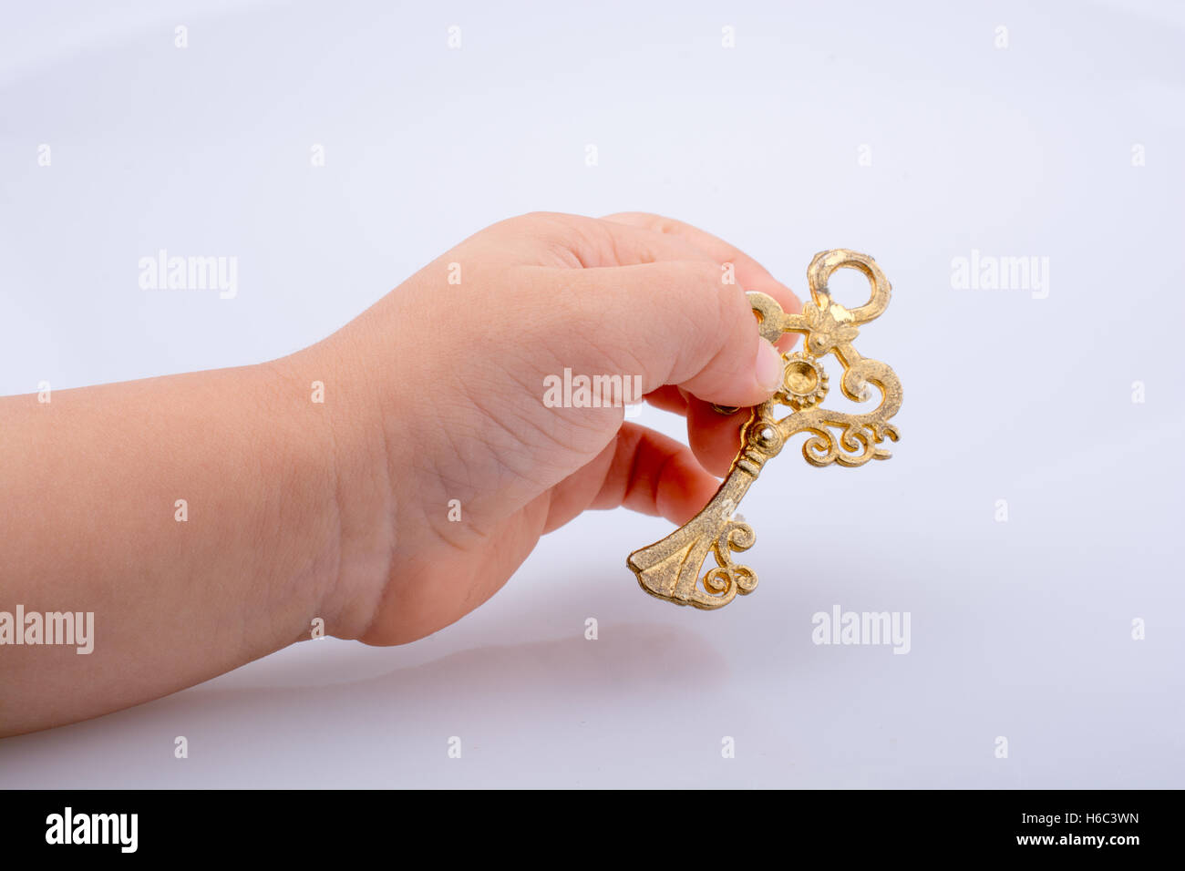 Child hand holding a retro styled decorative key Stock Photo - Alamy