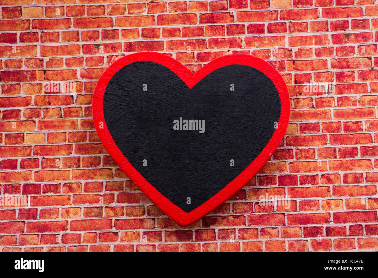 Red heart shape icon on a brick wall Stock Photo - Alamy