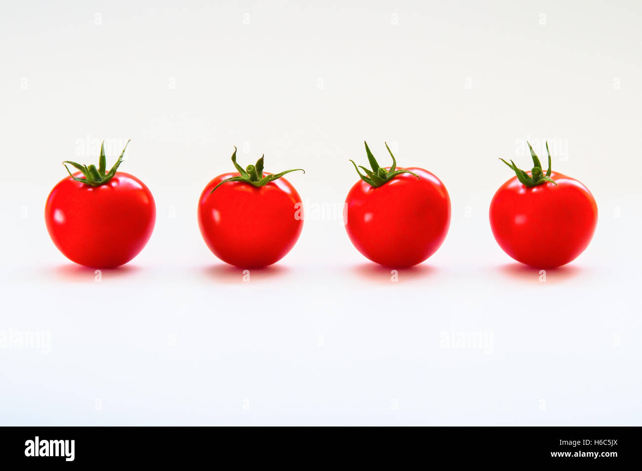 4 tomatoes in a row Stock Photo - Alamy